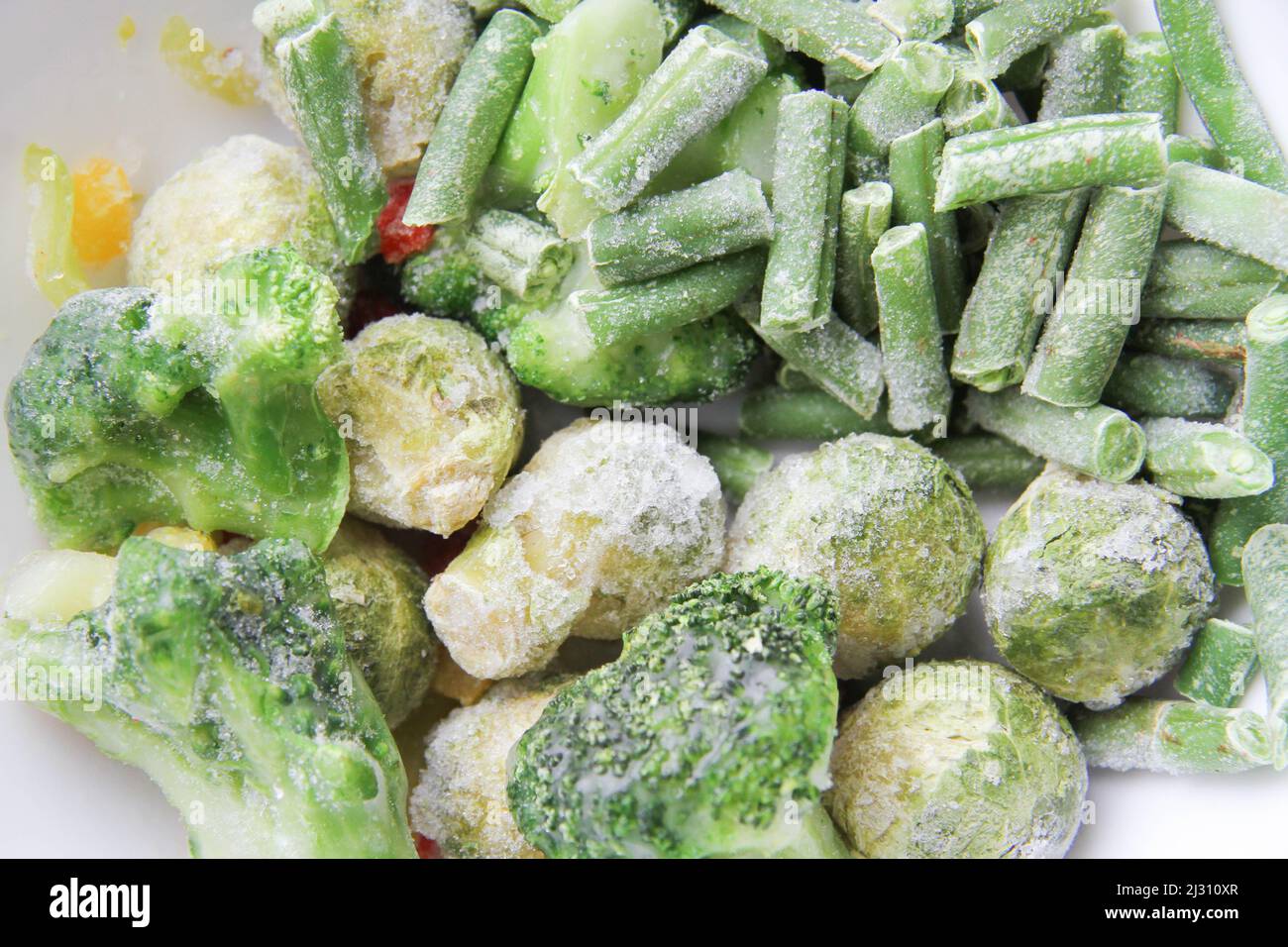 Frozen vegetables close up. Vegetables in the fridge. Ice on vegetables ...