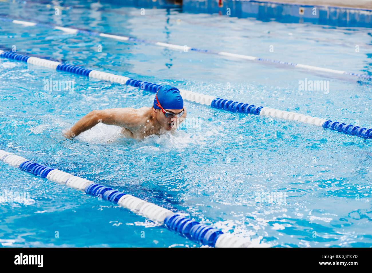 hispanic young man swimmer athlete wearing cap in a swimming training ...
