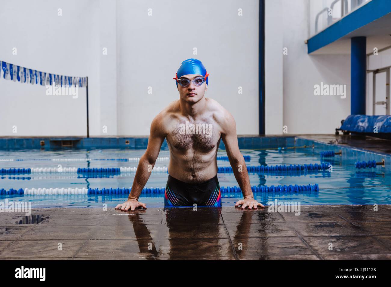 hispanic young man swimmer athlete wearing cap in a swimming training ...