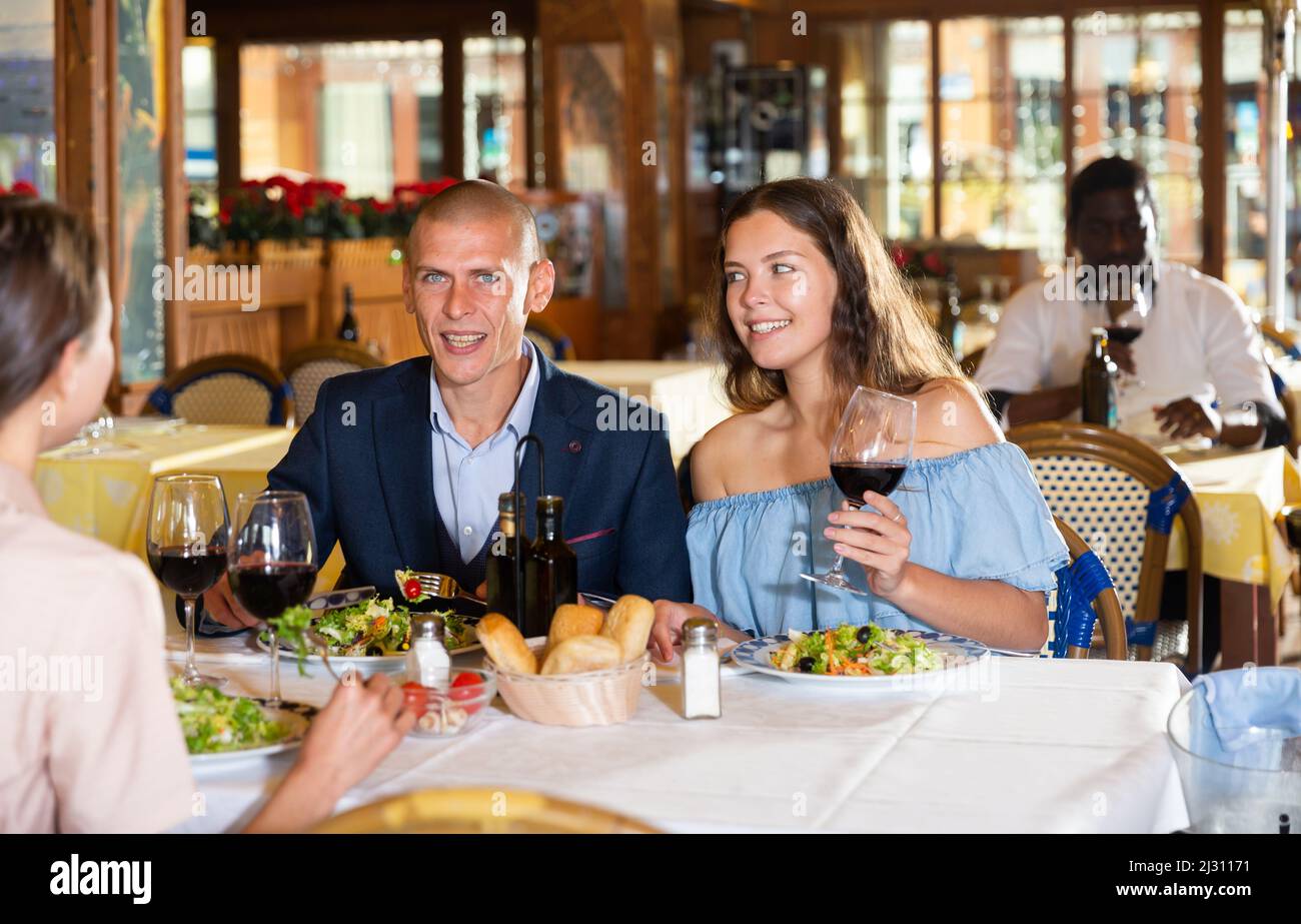 Company of smiling friends having dinner in restaurant Stock Photo - Alamy