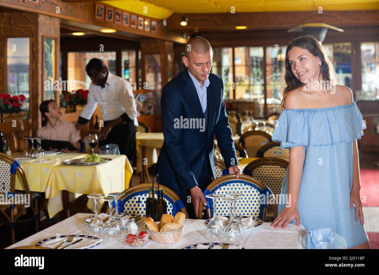 Couple choosing table for dinner at restaurant Stock Photo - Alamy