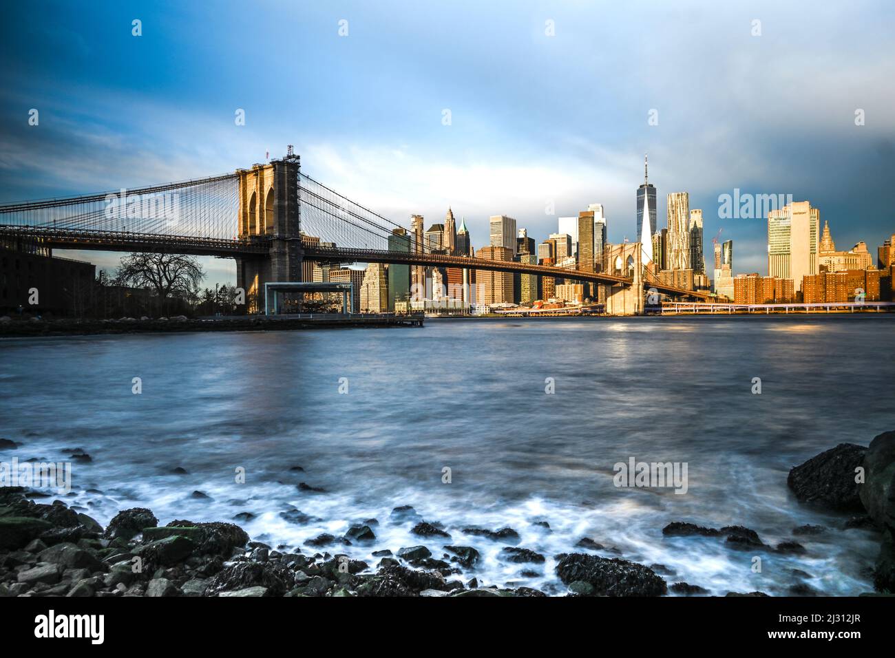view from the East River of the Brooklyn Bridge and Lower Manhattan ...