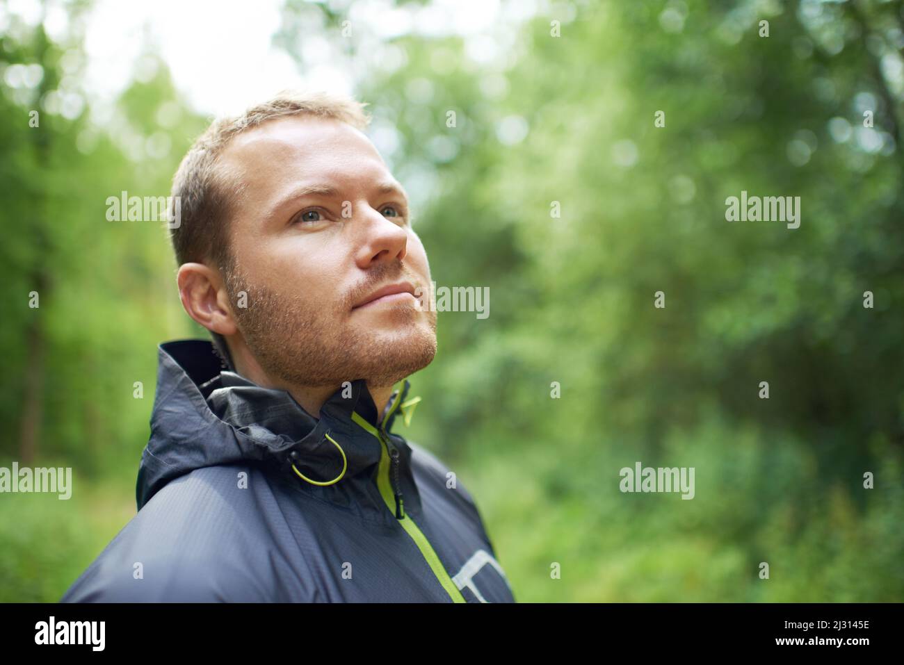 Feeling at one with nature. A young man looking at the nature around ...