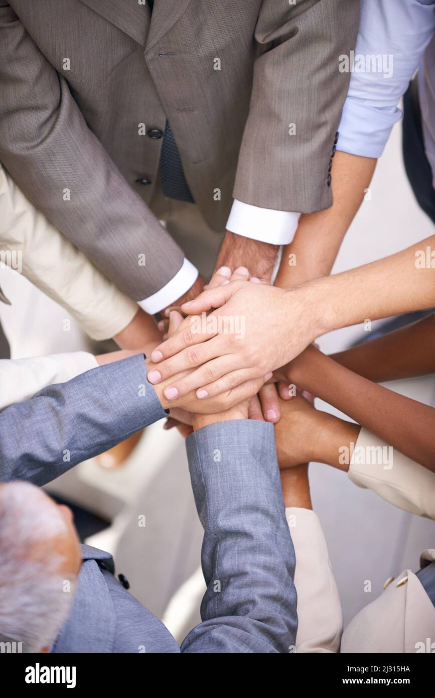 We can do this. Shot of a group of coworkers with their hands in a ...