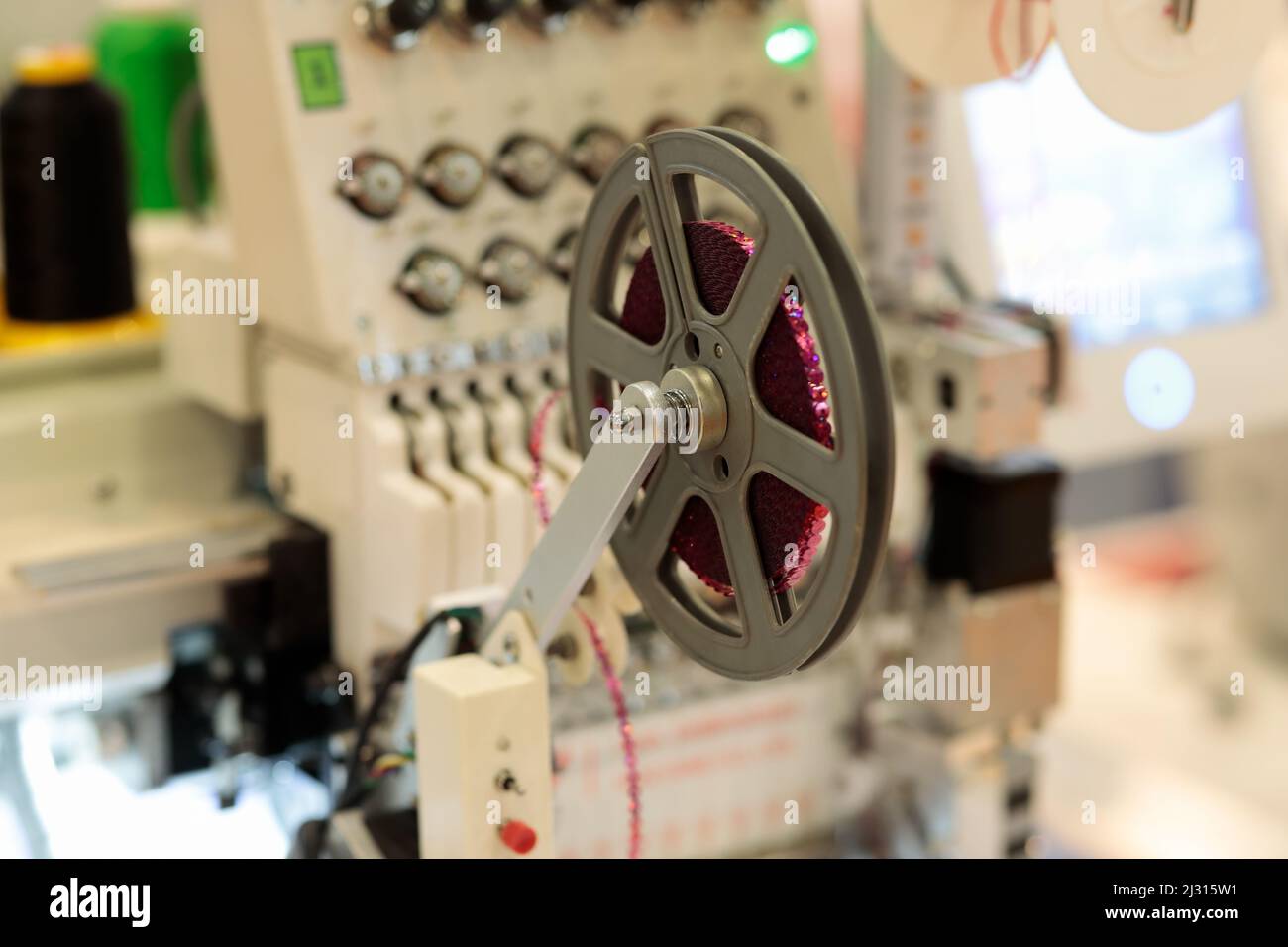 Automatic embroidery machine with plastic sequin reel. Selective focus ...