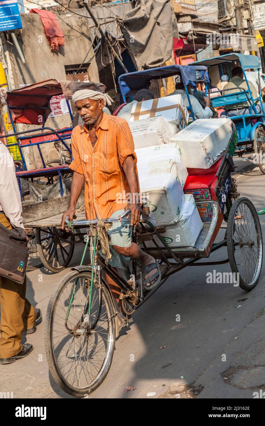 DELHI, INDIA - NOV 11, 2011: old rickshaw man has his rickshaw loaded ...
