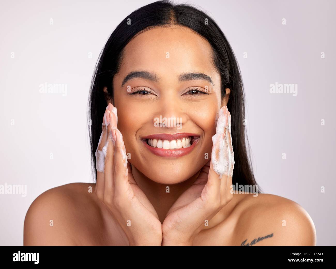 Keeping it clean. Studio portrait of an attractive young woman washing ...