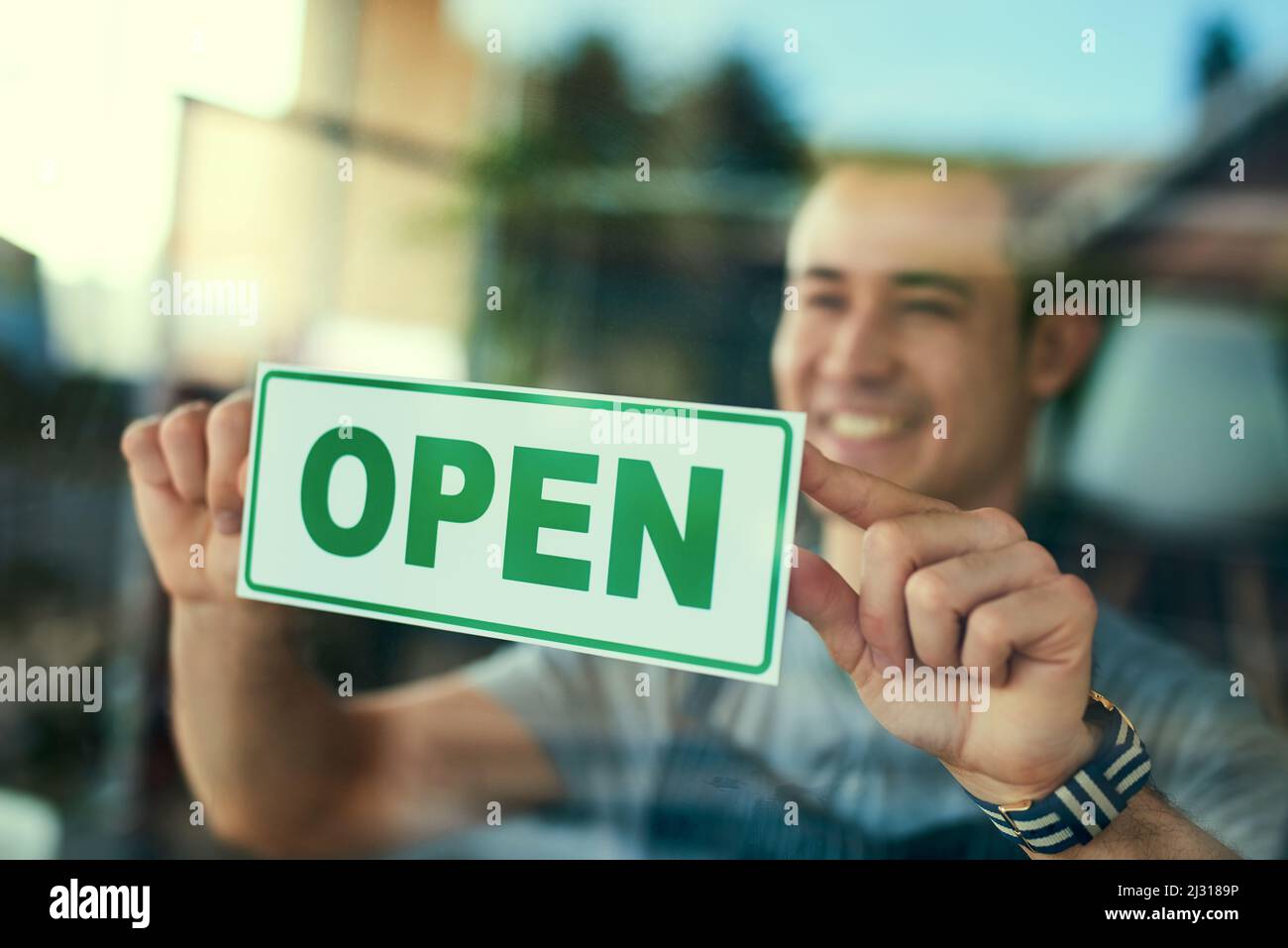 Were open. Cropped shot of a young man hanging the open sign in his ...