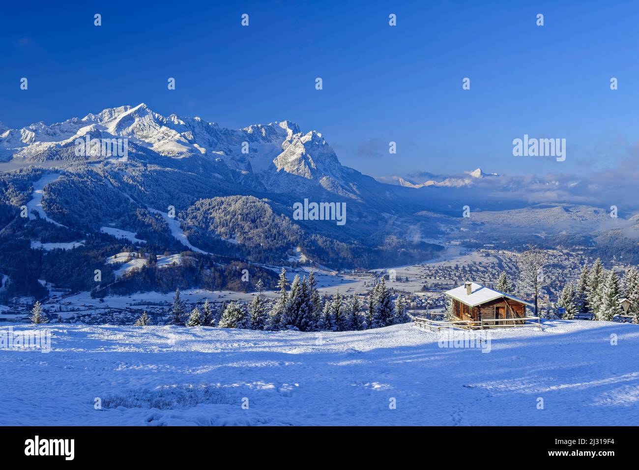 Snow-covered alpine pasture above Garmisch valley basin with ...