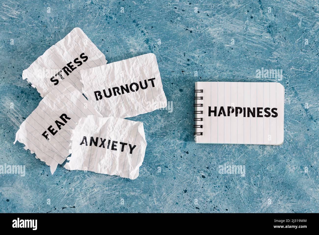 Happiness text on notepad with Fear Anxiety Stress and Burnout words on ...