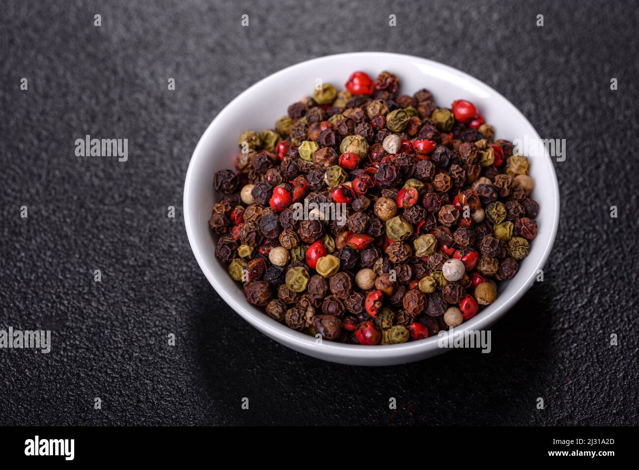 Pepper spice with peas of three different colors in a white saucer on a ...