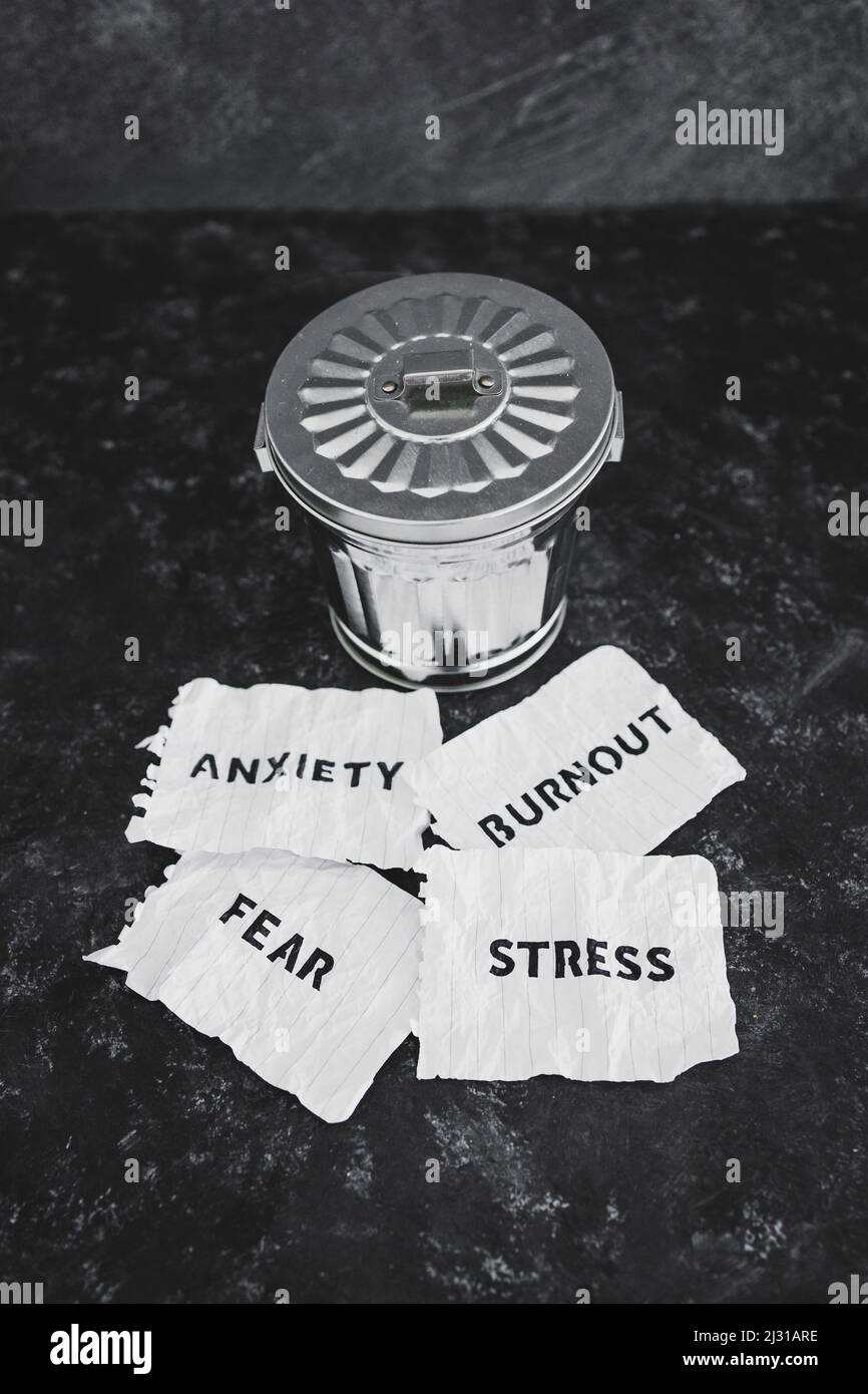 Anxiety Stress Fear and Burnout words on torn pages next to trash bin ...