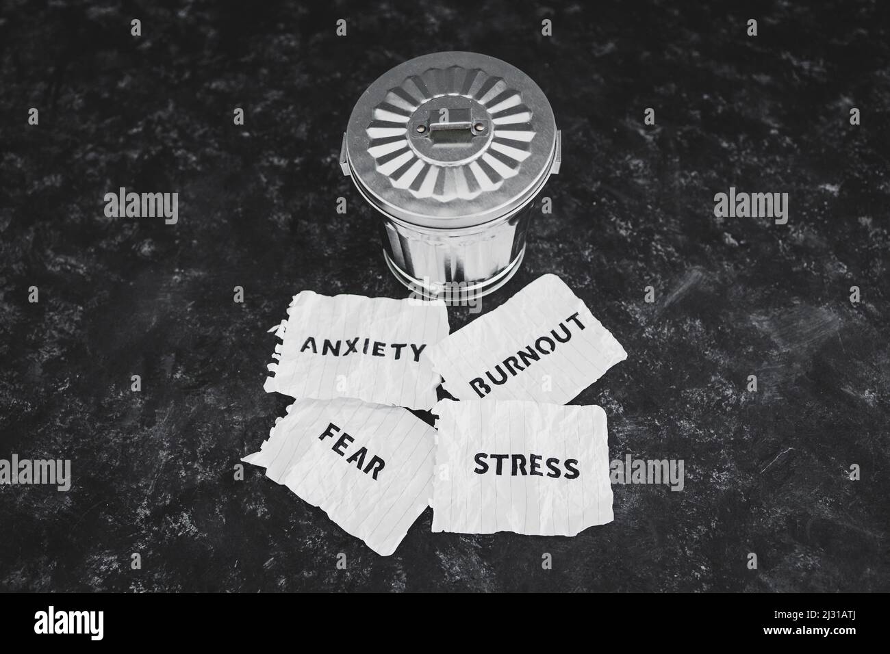 Anxiety Stress Fear and Burnout words on torn pages next to trash bin ...
