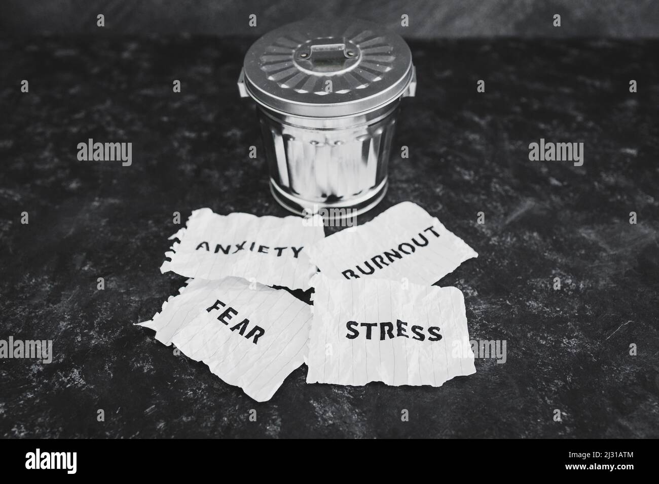 Anxiety Stress Fear and Burnout words on torn pages next to trash bin ...