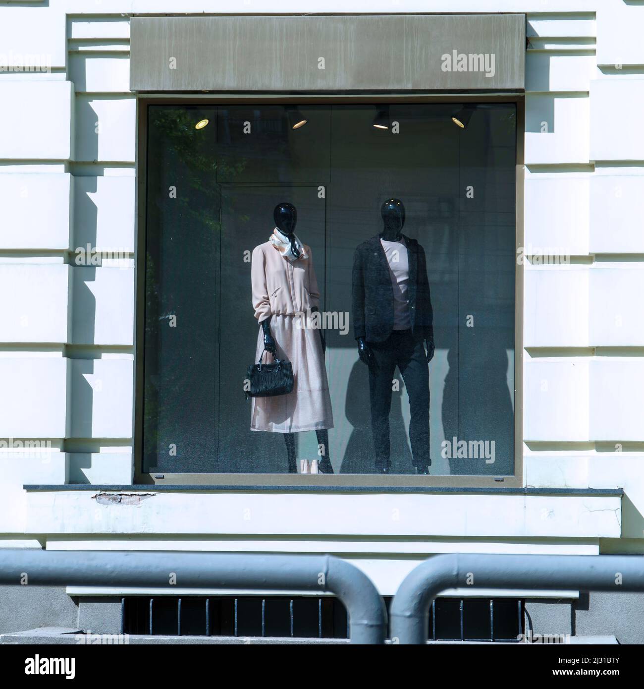 Two mannequins in a shop window on a showcase Stock Photo - Alamy