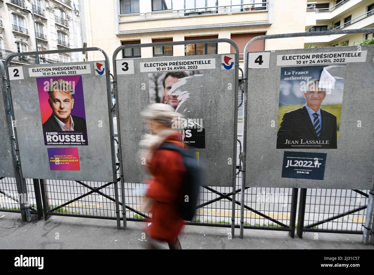 A pedestrian passes torn official campaign posters, on an electoral ...