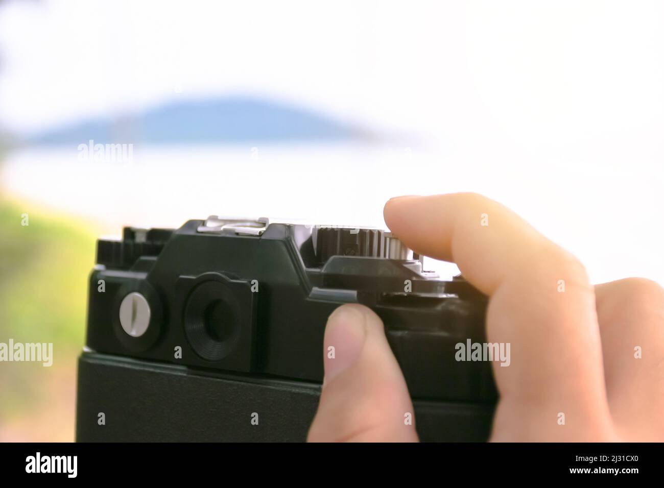 A tourist presses the shutter of a film camera to capture a photo of ...