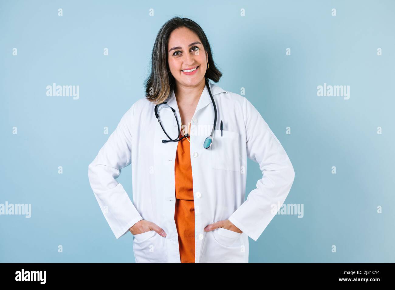 hispanic doctor woman portrait with copy space over blue background ...