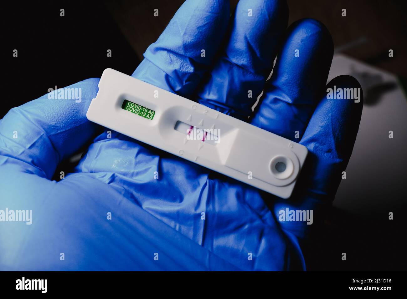 Covid-19 positive result cassette from a rapid antigen test kit on a ...