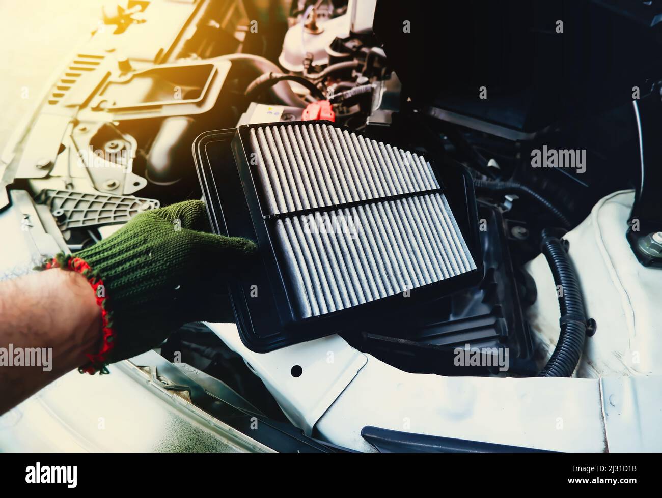A mechanic is replacing an air filter in the engine car filter socket ...
