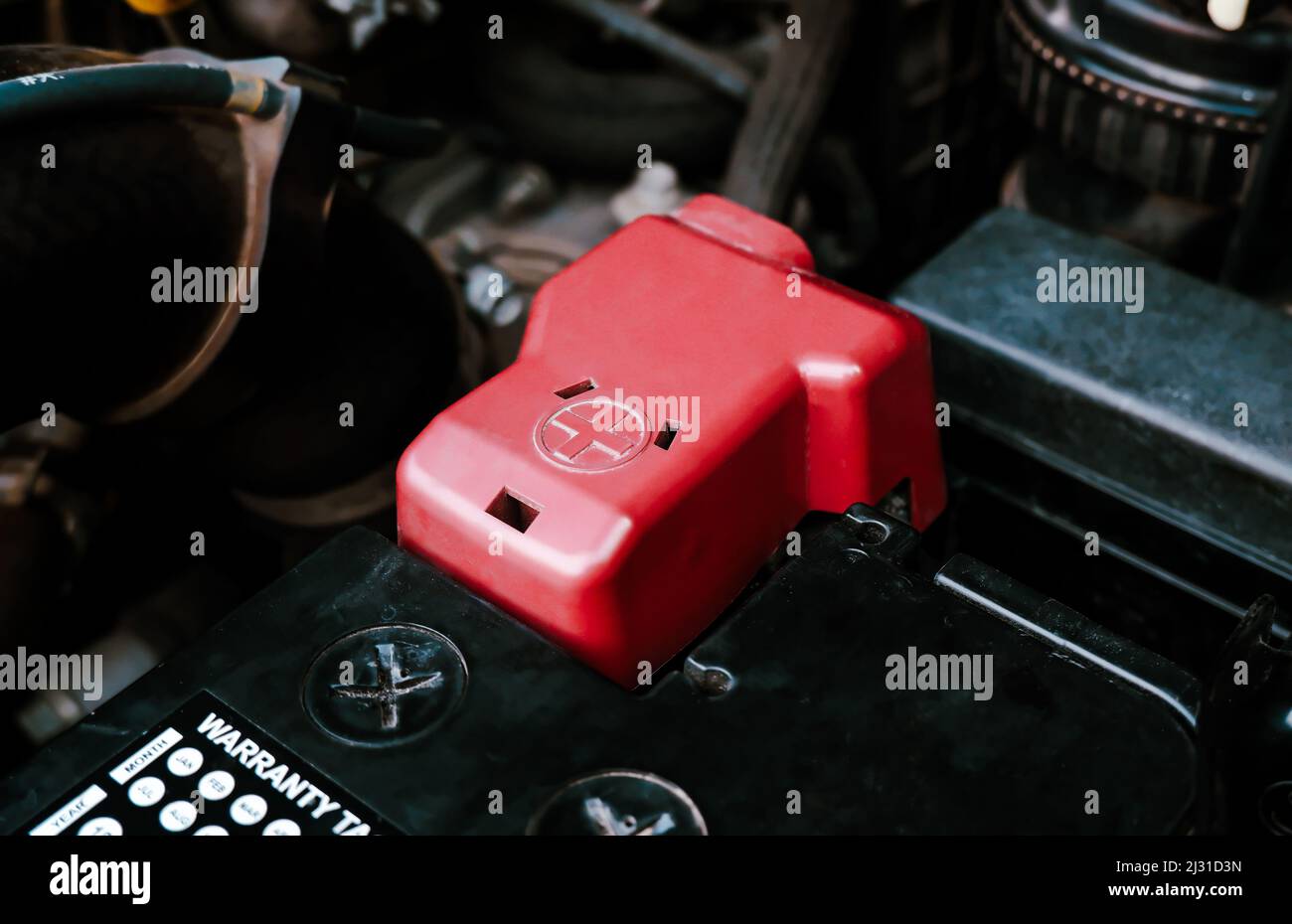 Battery anode terminal with red plastic cover is installed on a black ...