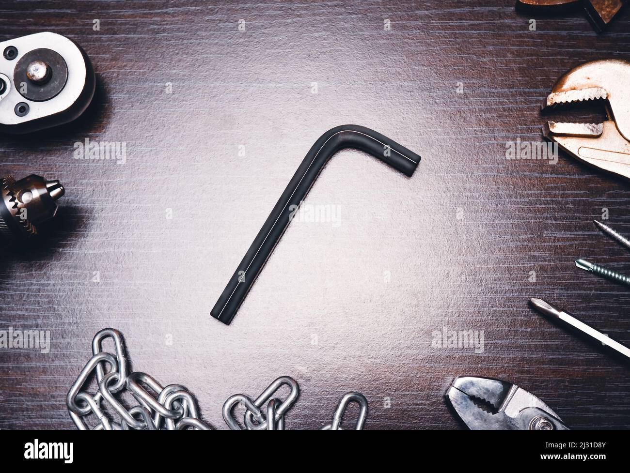 L shape hexagon tool on the hardwood table middle with mechanic tools ...