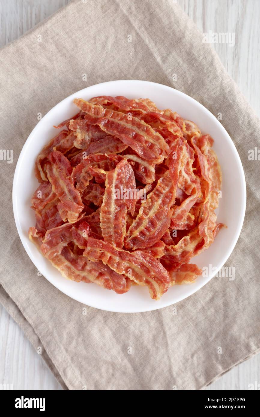 Crispy Fried Bacon on a white plate, top view. Flat lay, overhead, from ...