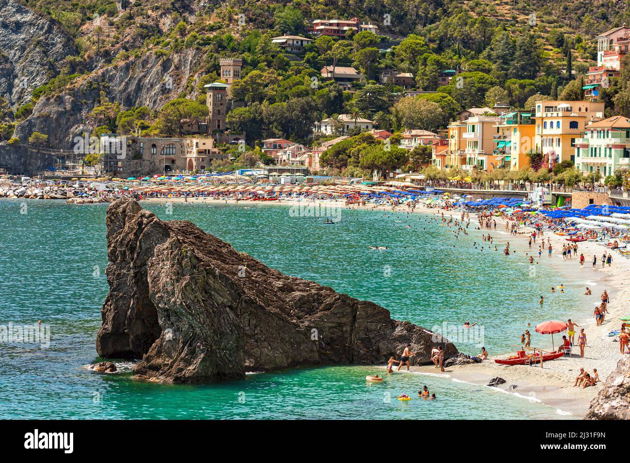 Imposing rock at the edge of the beach in the town of Monterosso. Many ...