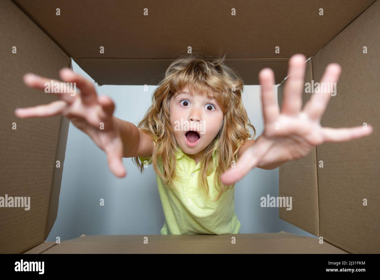 Surprised cute child opening a present. Cardboard boxes, parcels ...