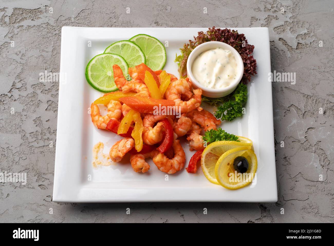 Shrimps fried with vegetables on white plate with sauce Stock Photo - Alamy