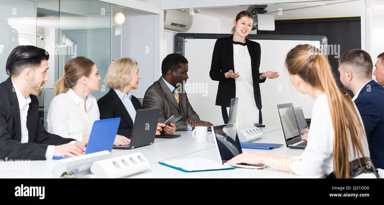 Positive businesswoman presenting new business projects to partners ...