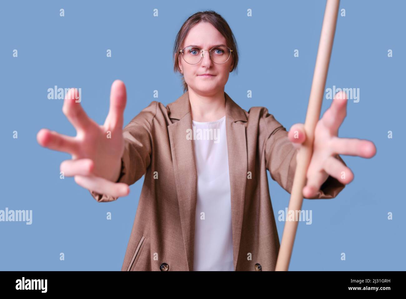 Woman teacher pulls her hands forward and wants to grab on studio blue ...