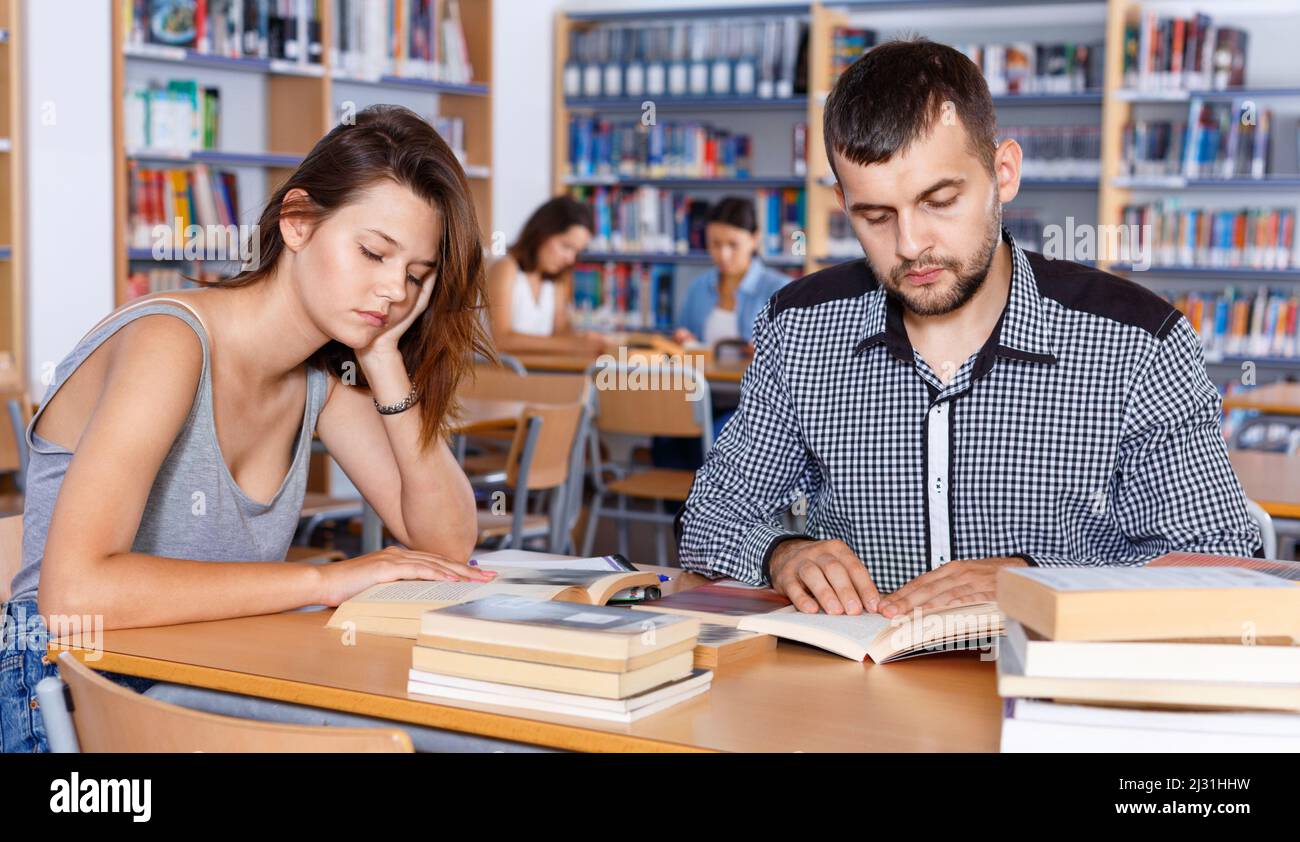 Young people reading and making notes while preparing for exam in ...