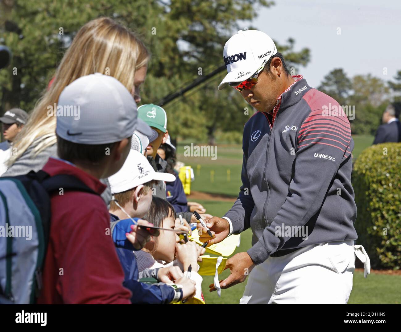 Defending Masters champion Hideki Matsuyama (R) signs autographs for ...