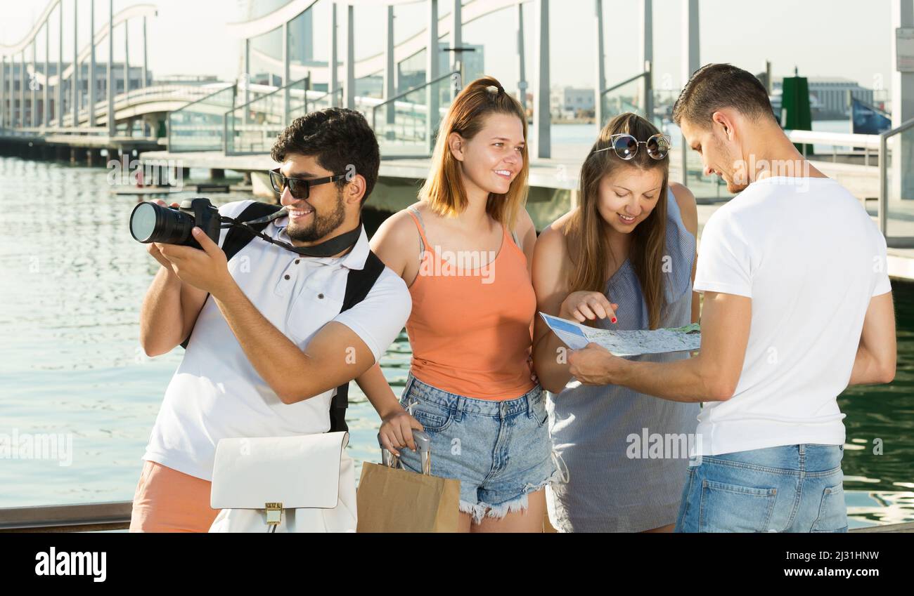 positive tourists looking at the map Stock Photo - Alamy