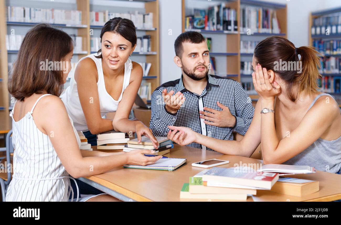 Happy young university students preparing for exam together ...