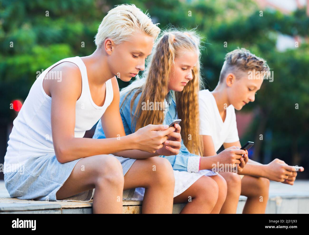Modern kids using mobile gadgets Stock Photo - Alamy