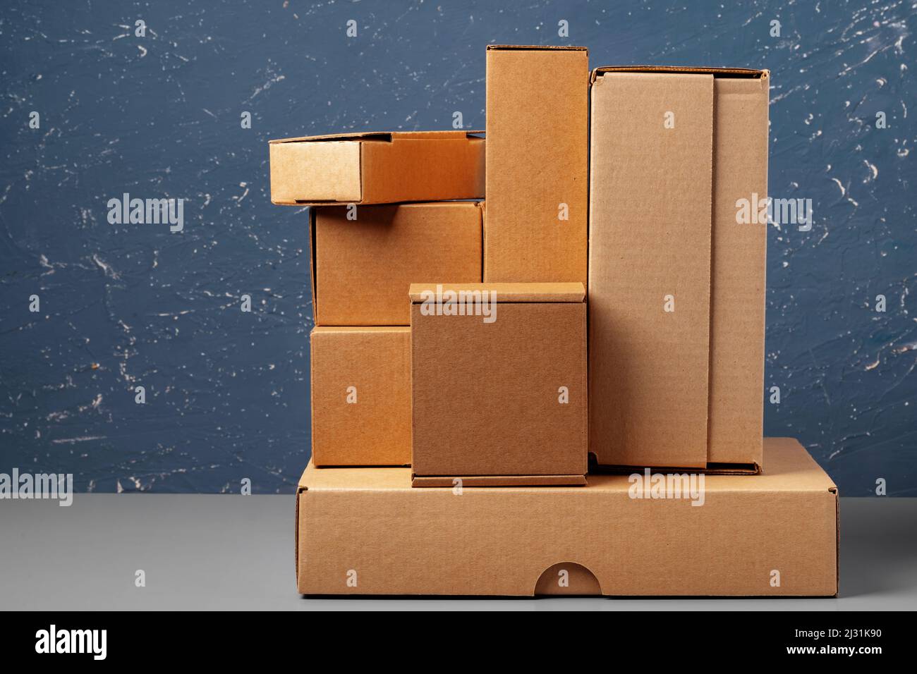 Group of cardboard boxes against blue background Stock Photo - Alamy