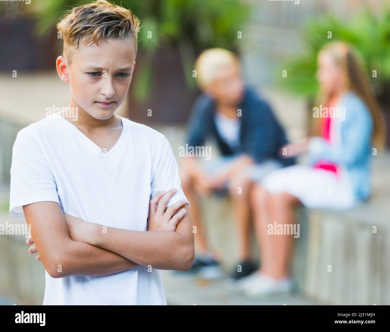 Sad boy having problems with friends Stock Photo - Alamy