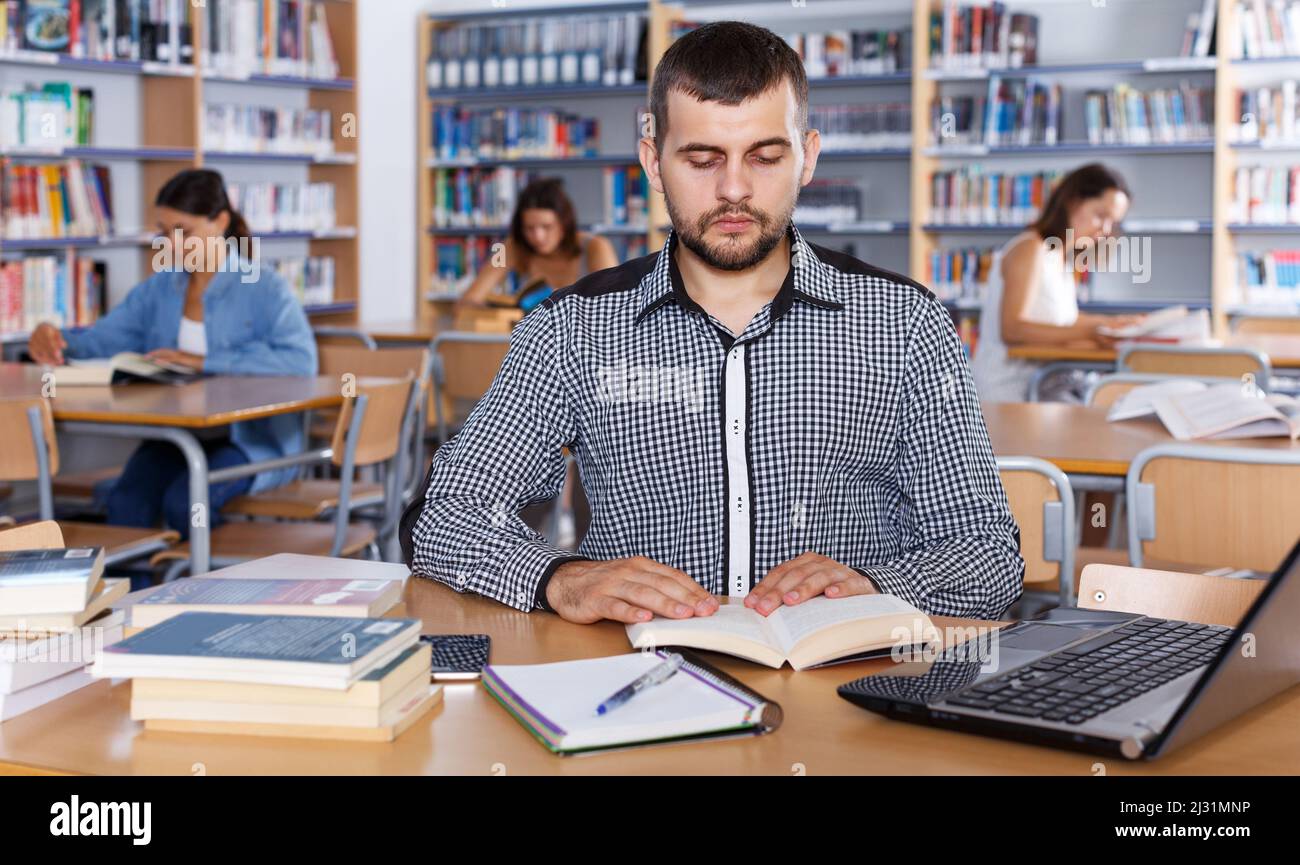 man engaged in research, working with laptop and books Stock Photo - Alamy