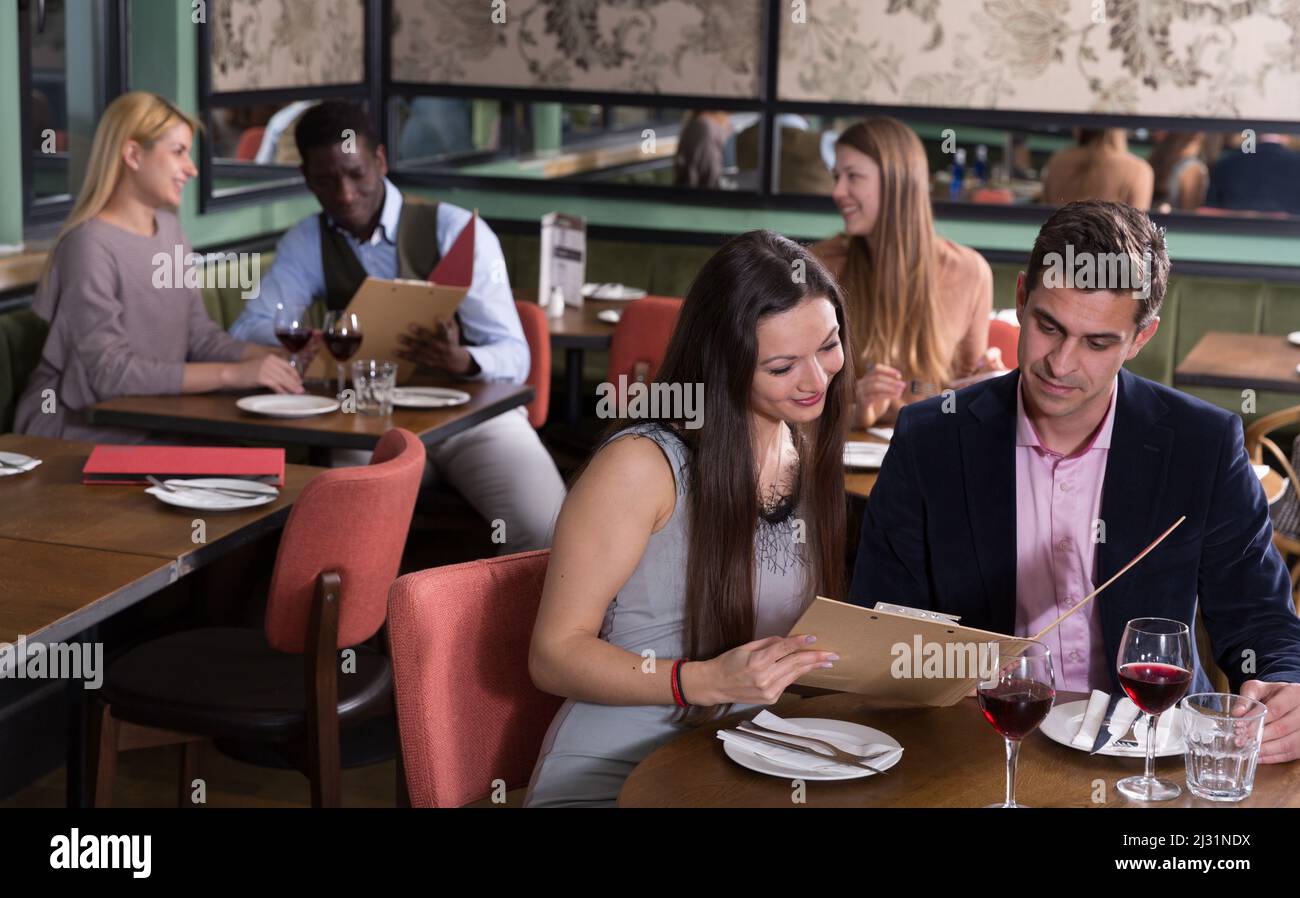 Smiling friends discussing menu restaurant hi-res stock photography and ...