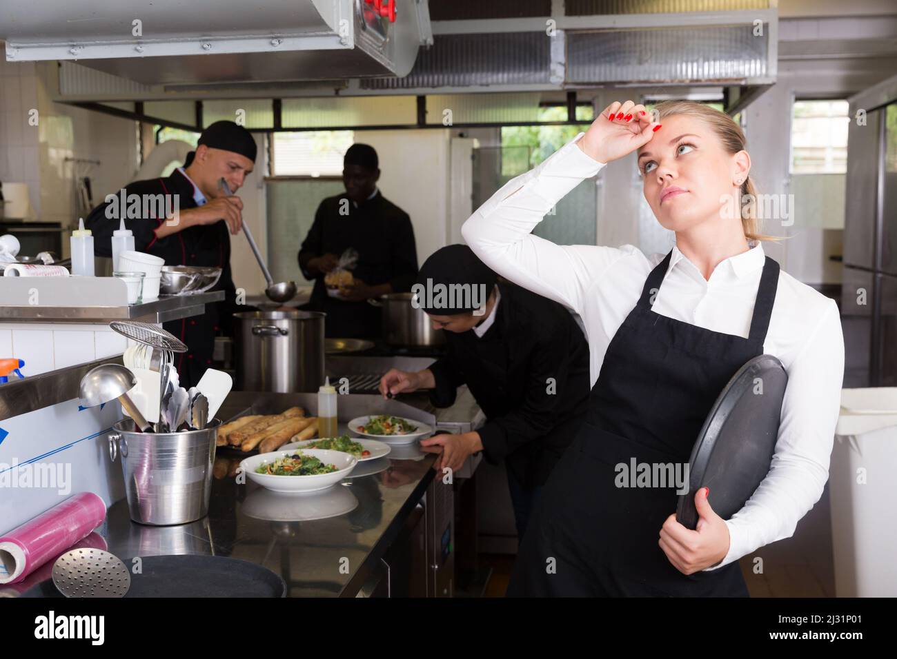 Unhappy waitress waiting dishes in kitchen Stock Photo - Alamy