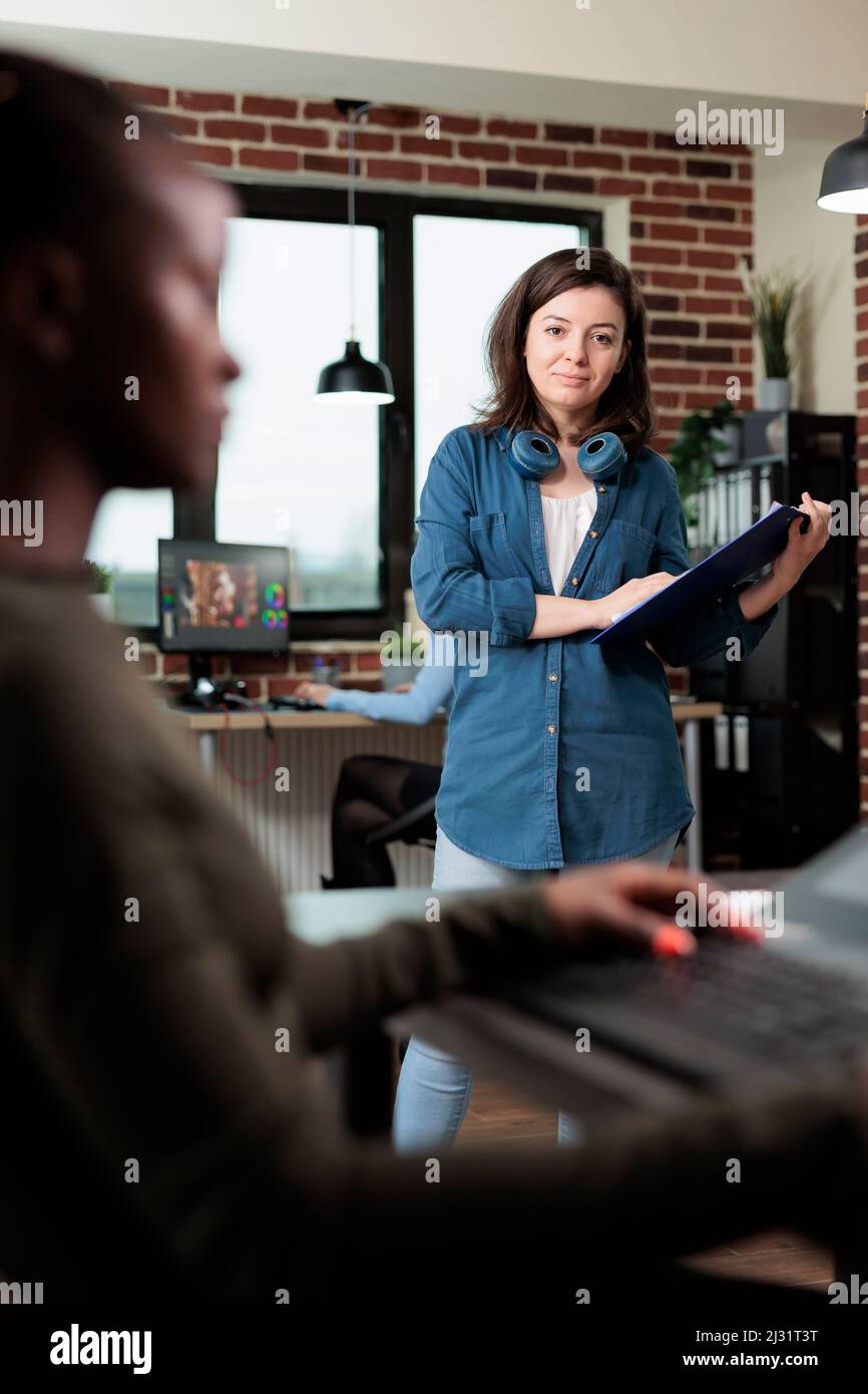 Creative company professional worker standing in front of vertical ...