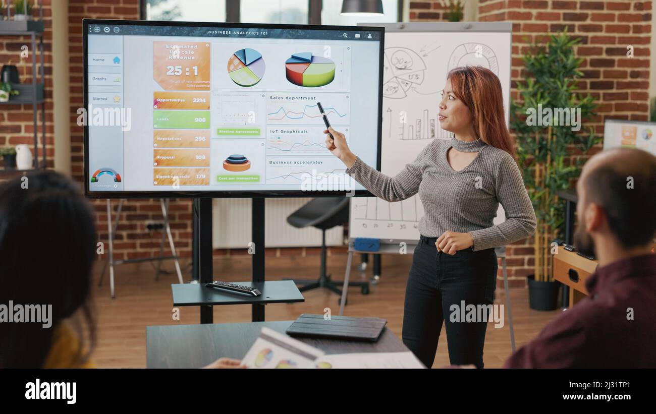 Company workers planning business presentation, collaborating on graphs and charts to research ...