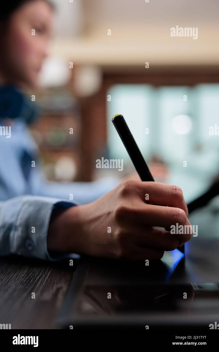 Close up of digital photo editor sitting at desk with multiple displays ...