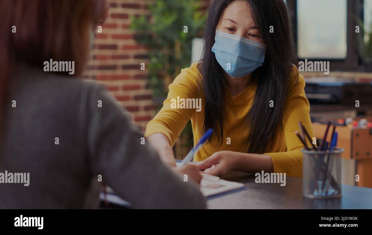 HR employee meeting with applicant at job interview during pandemic in ...
