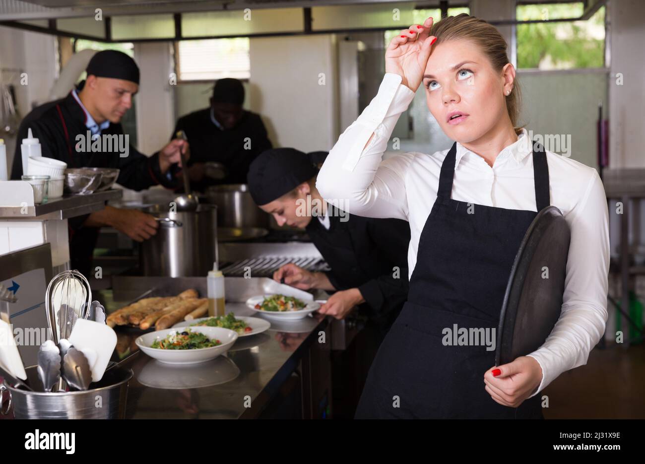 Disappointed waitress in restaurant kitchen Stock Photo - Alamy