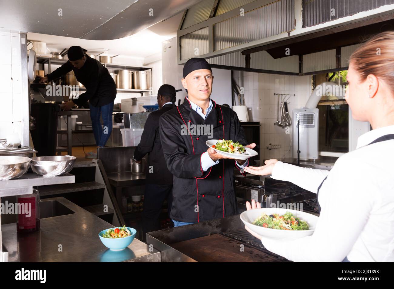 Staff of restaurant with chef working Stock Photo - Alamy