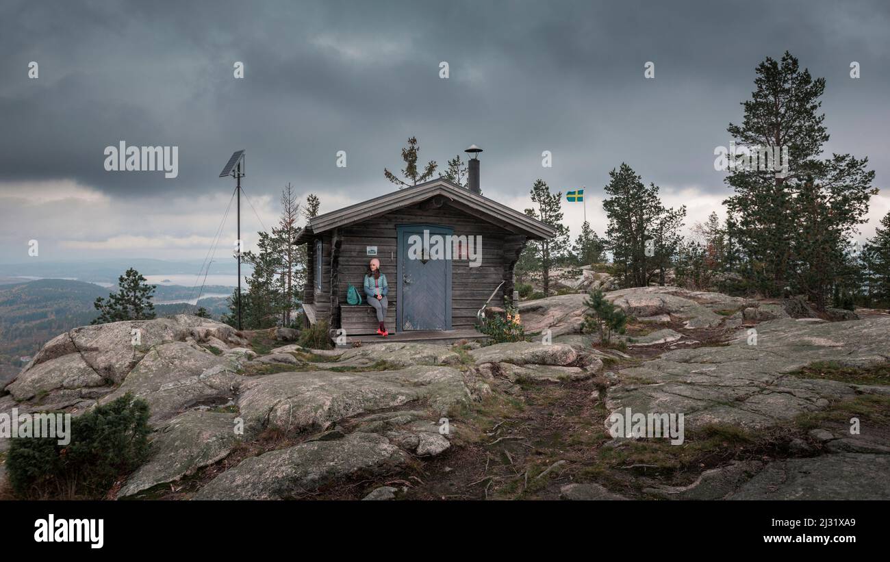 Woman sitting at a refuge on the summit of Valkallen in Höga Kusten in ...