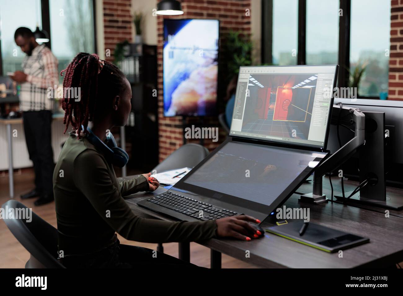 Game developer sitting in creative agency office workspace while ...